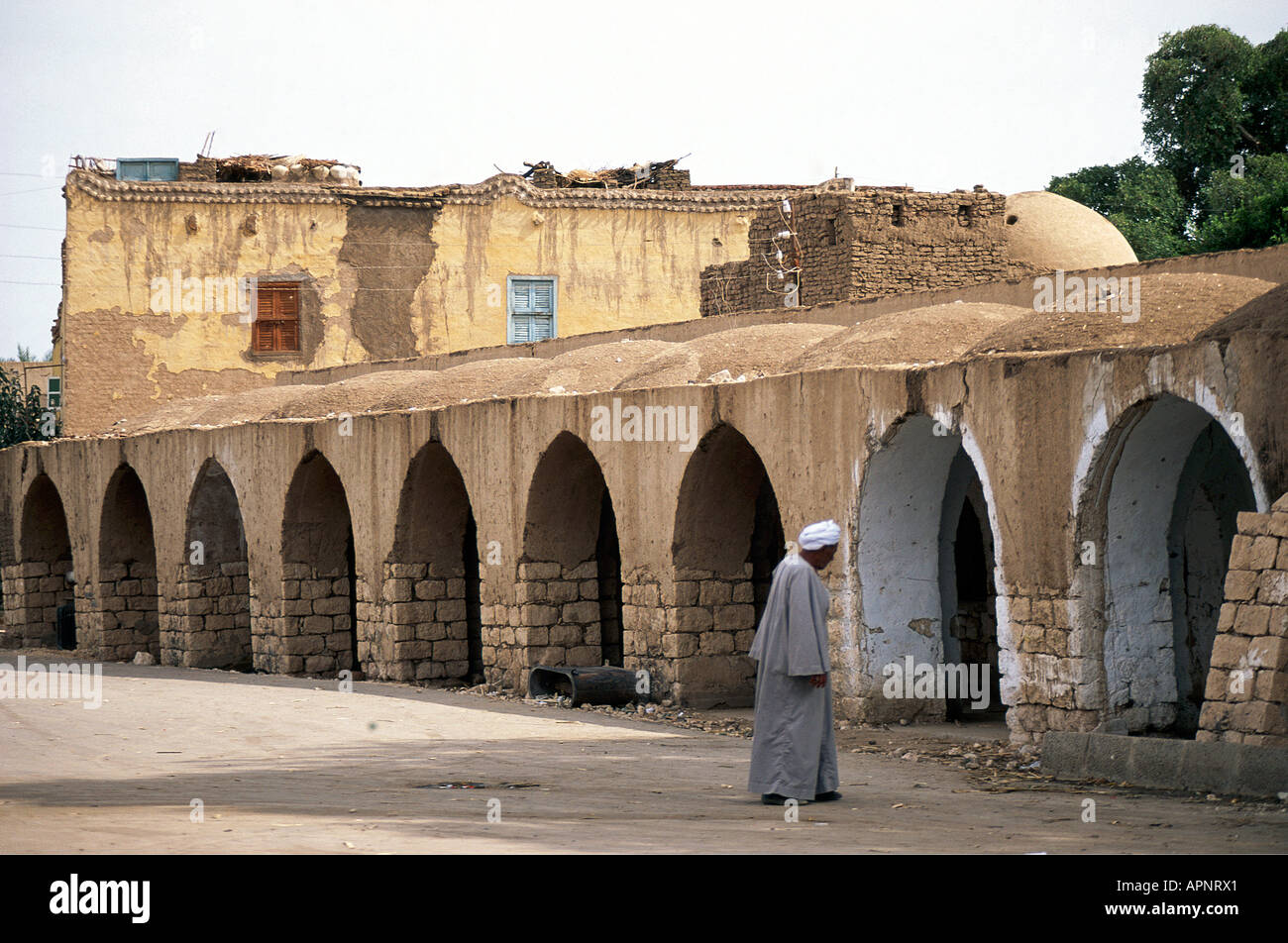 An old Arab walking towards the arches of a building in New Gurna built ...
