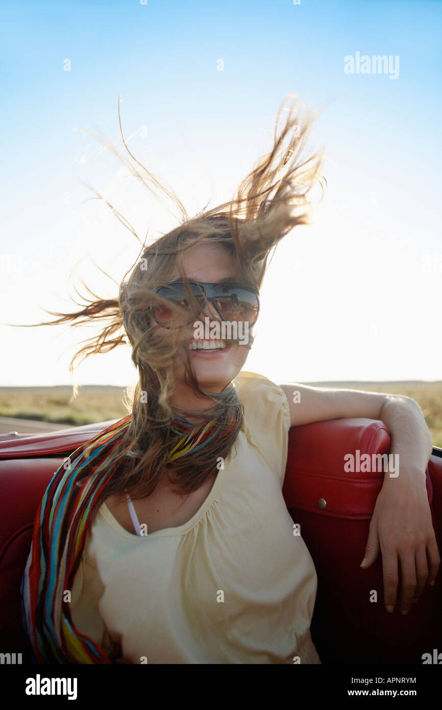 Young woman with wind swept hair in convertible Stock Photo - Alamy