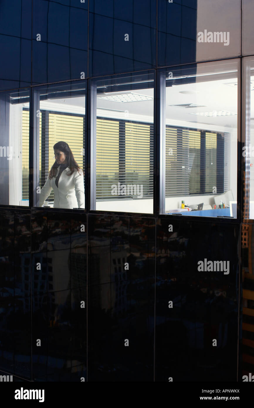 Businesswoman looking through office window (exterior view Stock Photo ...