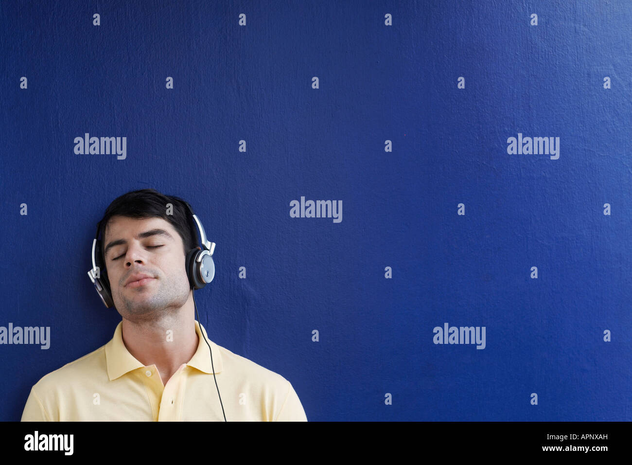 Young man listening to headphones Stock Photo - Alamy