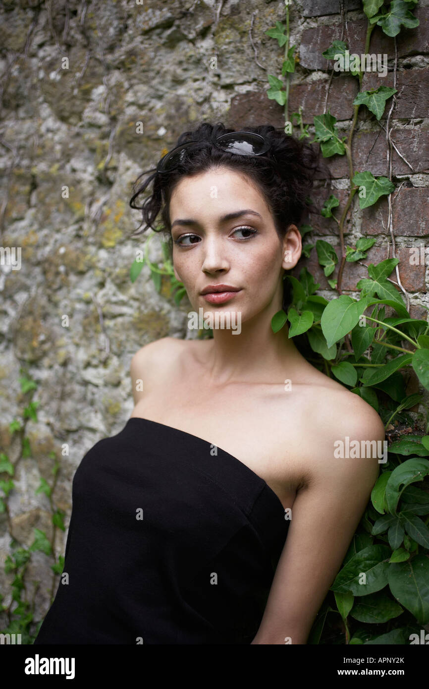 Young woman leaning on wall Stock Photo - Alamy