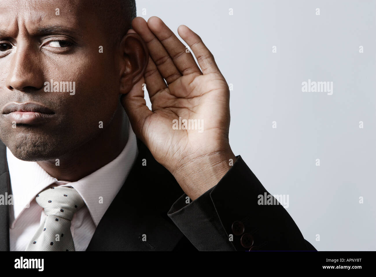Businessman listening with hand on ear Stock Photo - Alamy