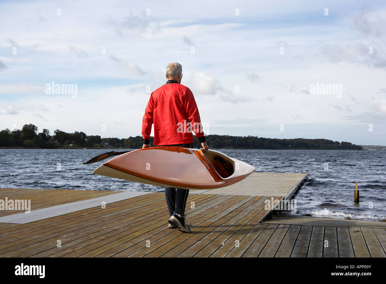 Senior man carrying a kayak Stock Photo - Alamy
