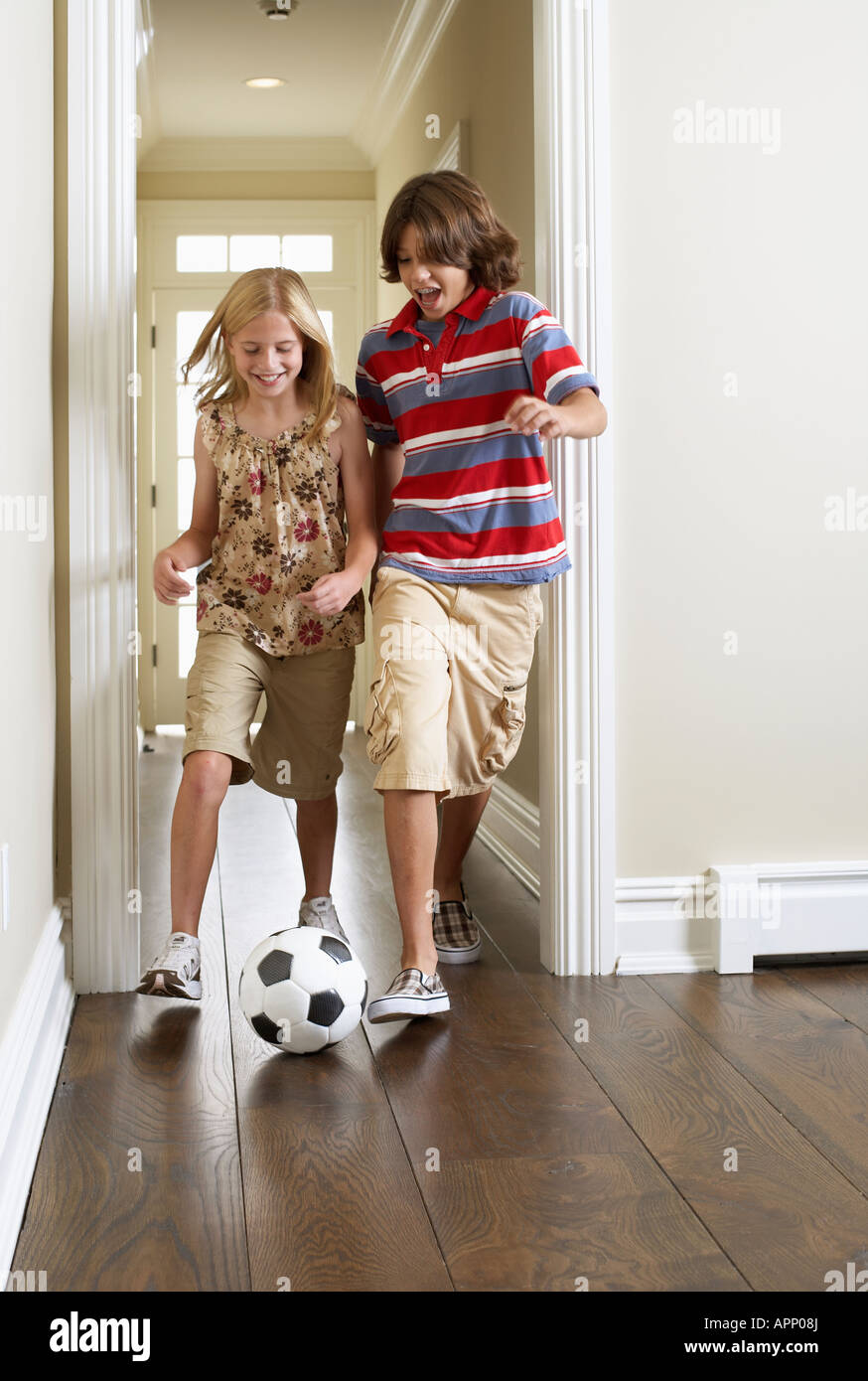 Sister and brother playing soccer indoors Stock Photo - Alamy