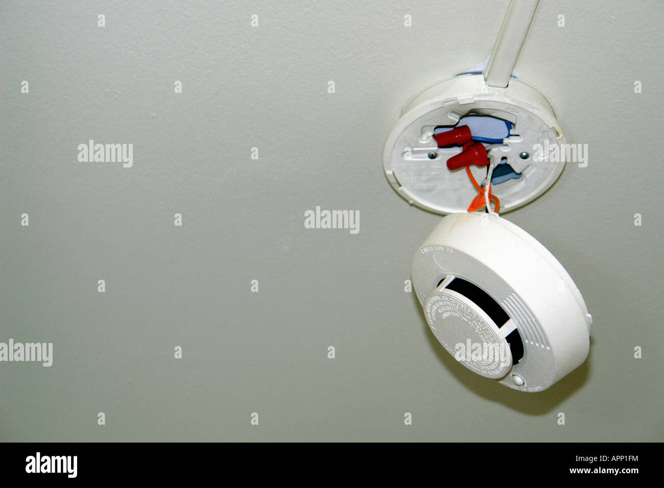 Disconnected Plastic Smoke Detector Alarm Hanging From a Ceiling Viewed ...