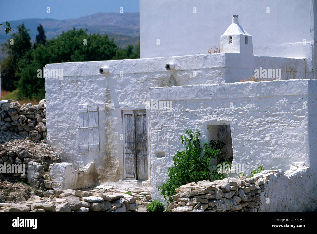 Detail of an old whitewashed house with drystone walls in front and ...