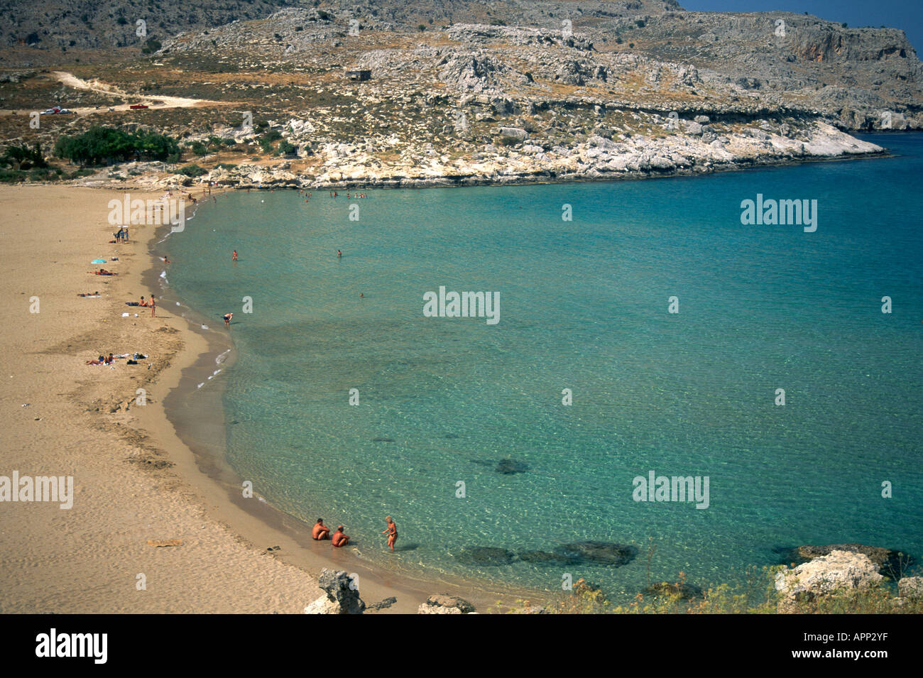 People at the water s edge on the crescent shaped pebbly Agathi beach ...