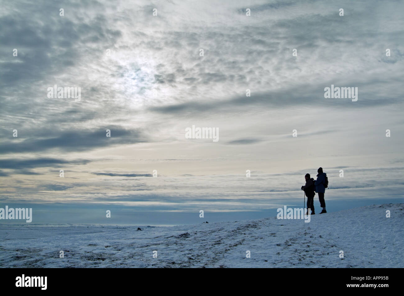 Two hikers on the top of Mam tor looking at Castleton Derbyshire Peak ...