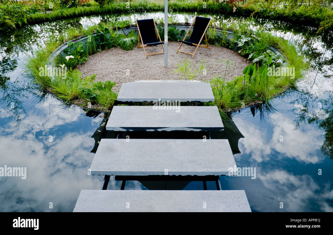 Circular swimming pool with reflected clouds. Stepping stone causeway ...
