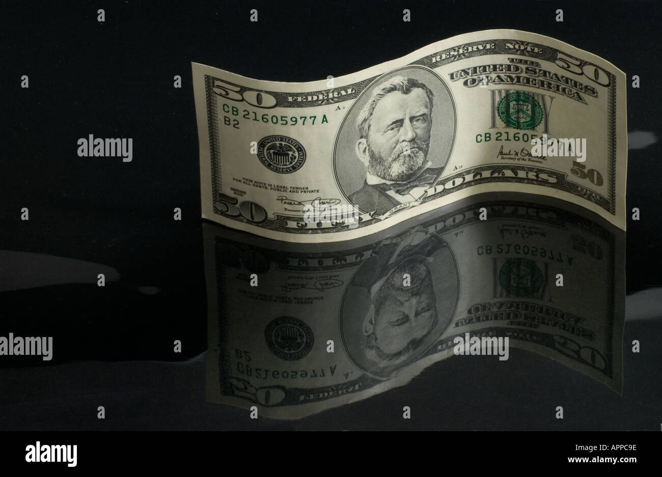 American 50 dollar bill with its reflection on black grey background ...