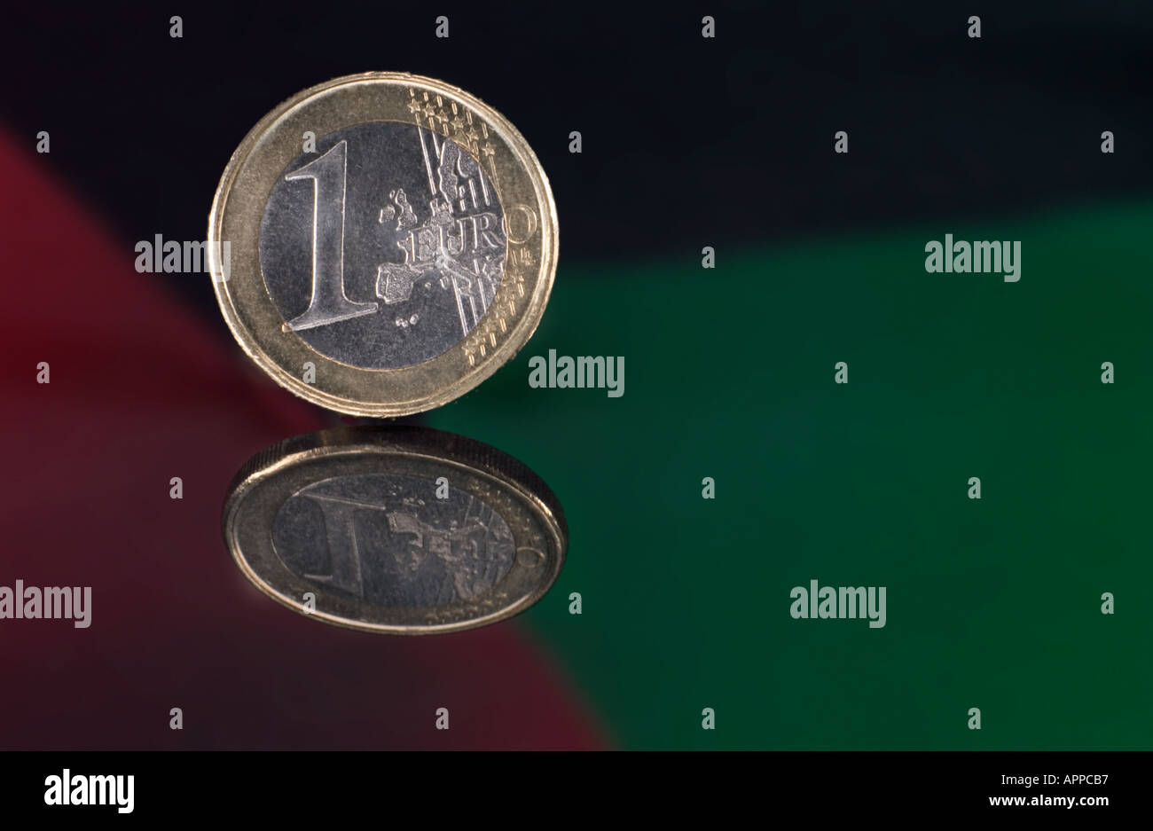 One euro coin and its mirror reflection on black green red background ...