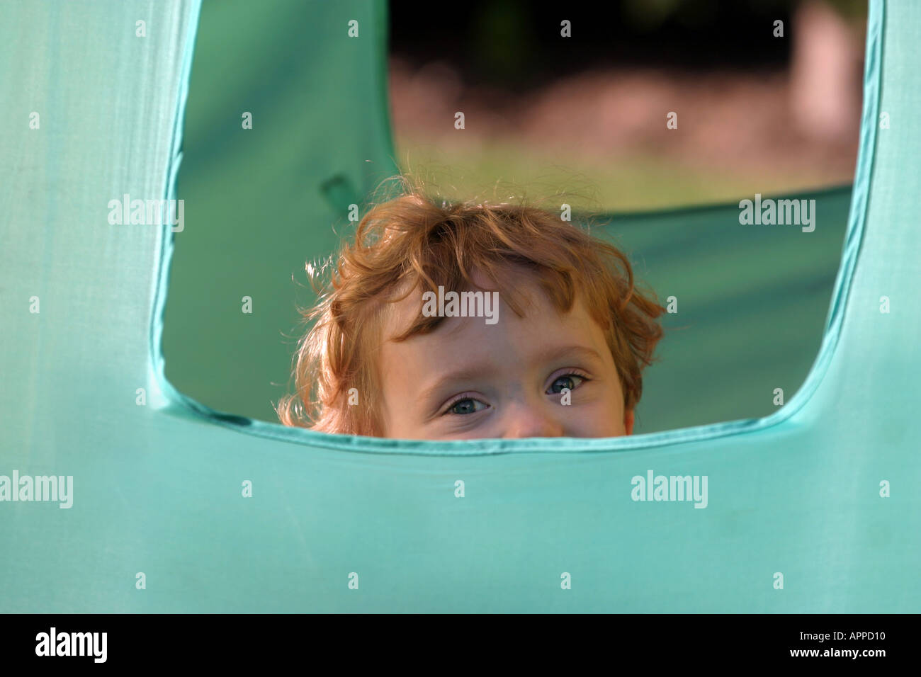 Lewis aged three peeks out of a tent Stock Photo - Alamy