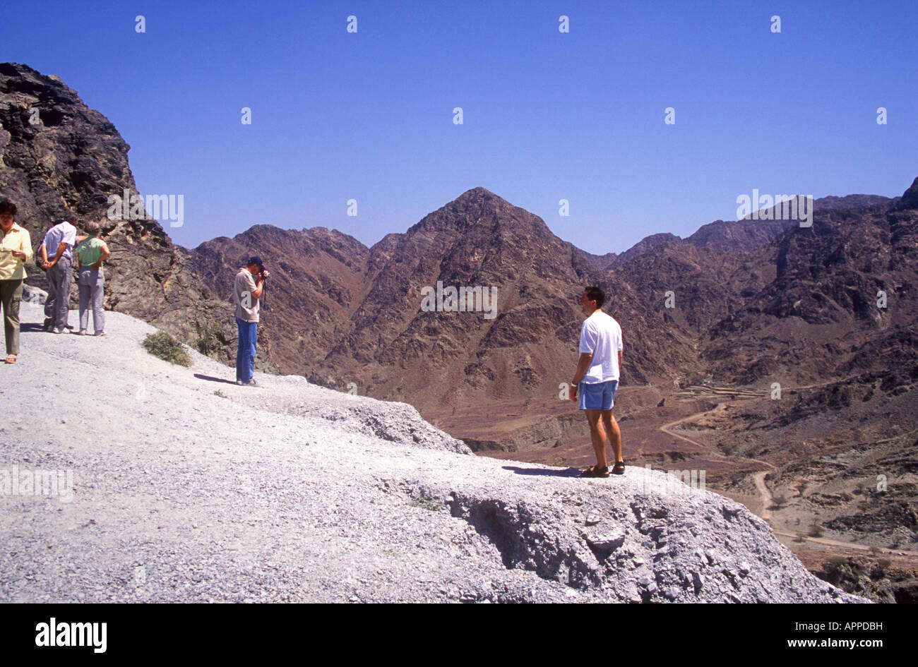 UAE - Tourists view a large wadi in the Fujairah Hajar Mountains Stock ...