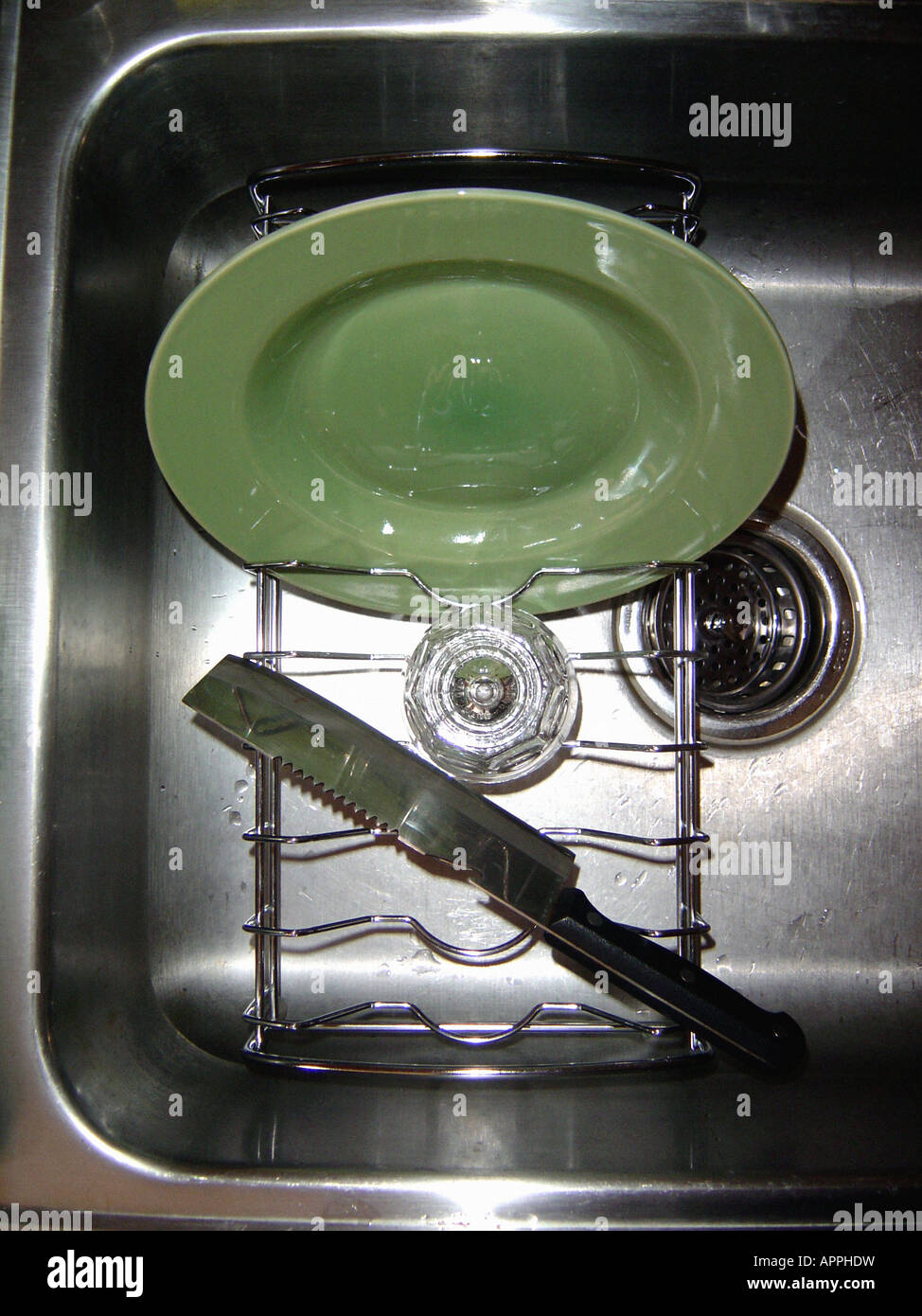 Domestic Scene of a Green Plate and a Knife Drying in a Dish Rack in a ...