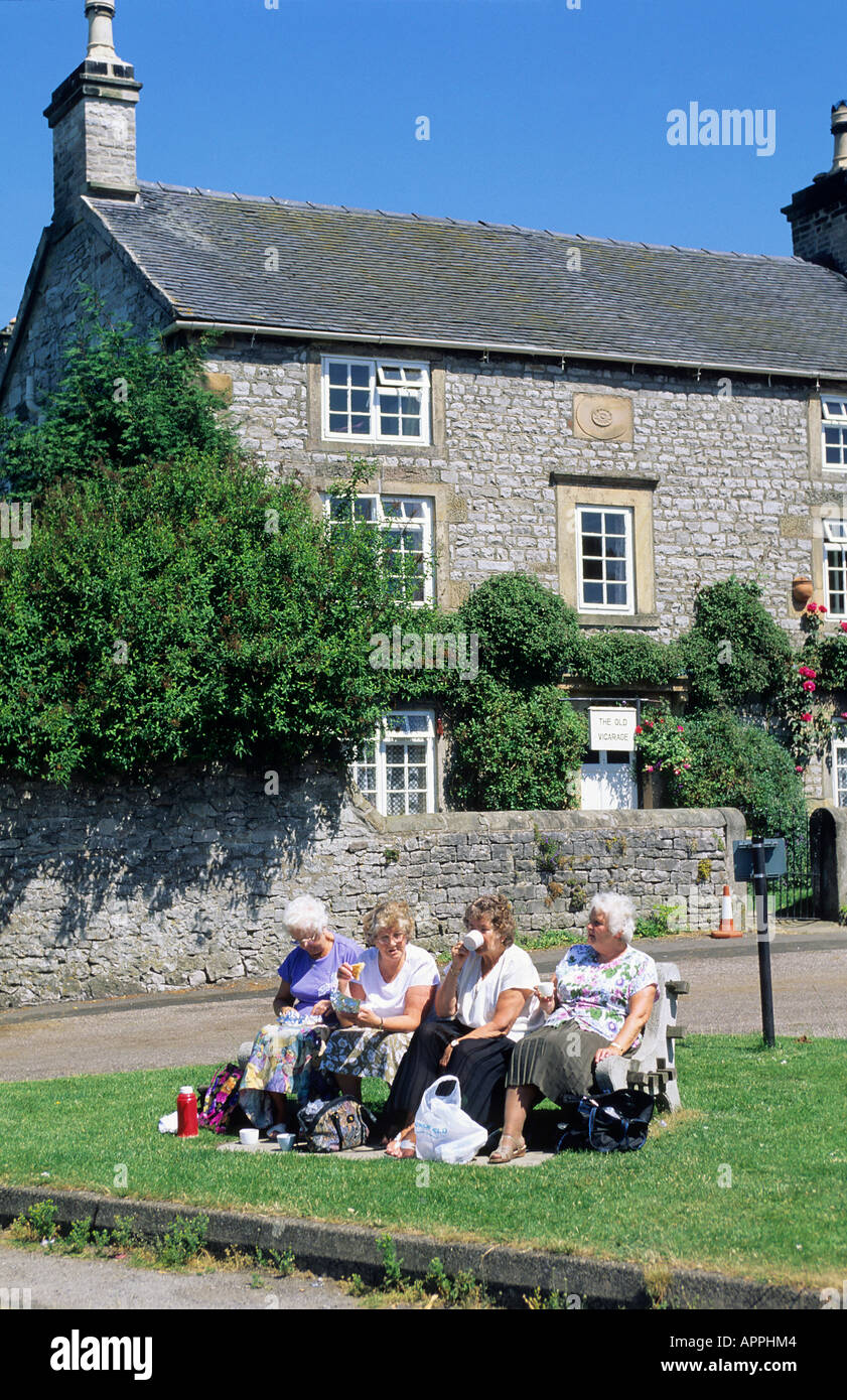 Four elderly women taking refreshment on the village green with the Old ...