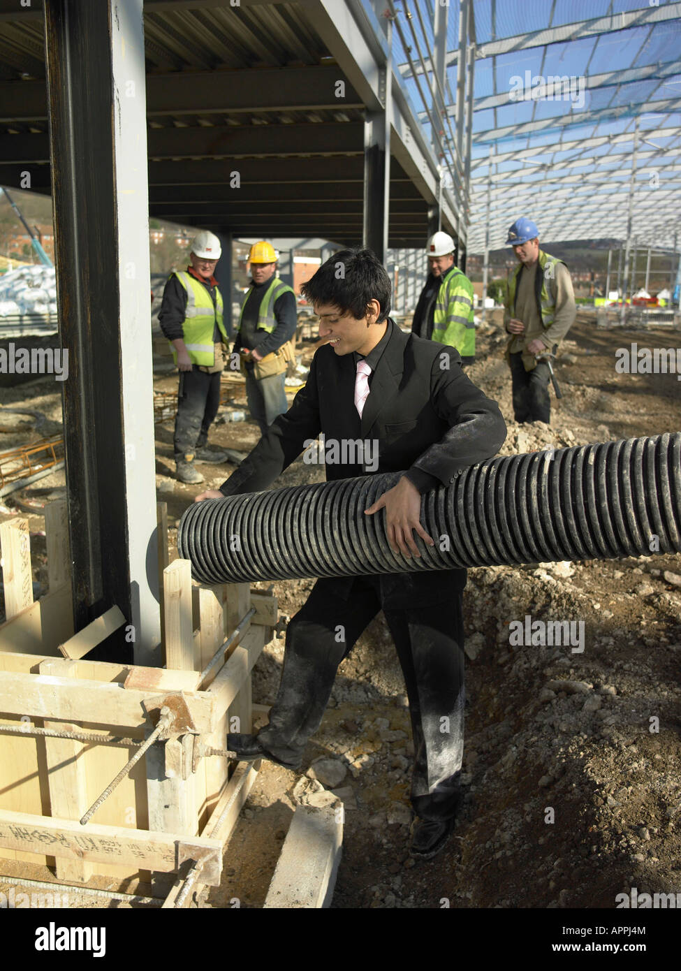 Business man in a suit on a building site pouring cement Stock Photo ...