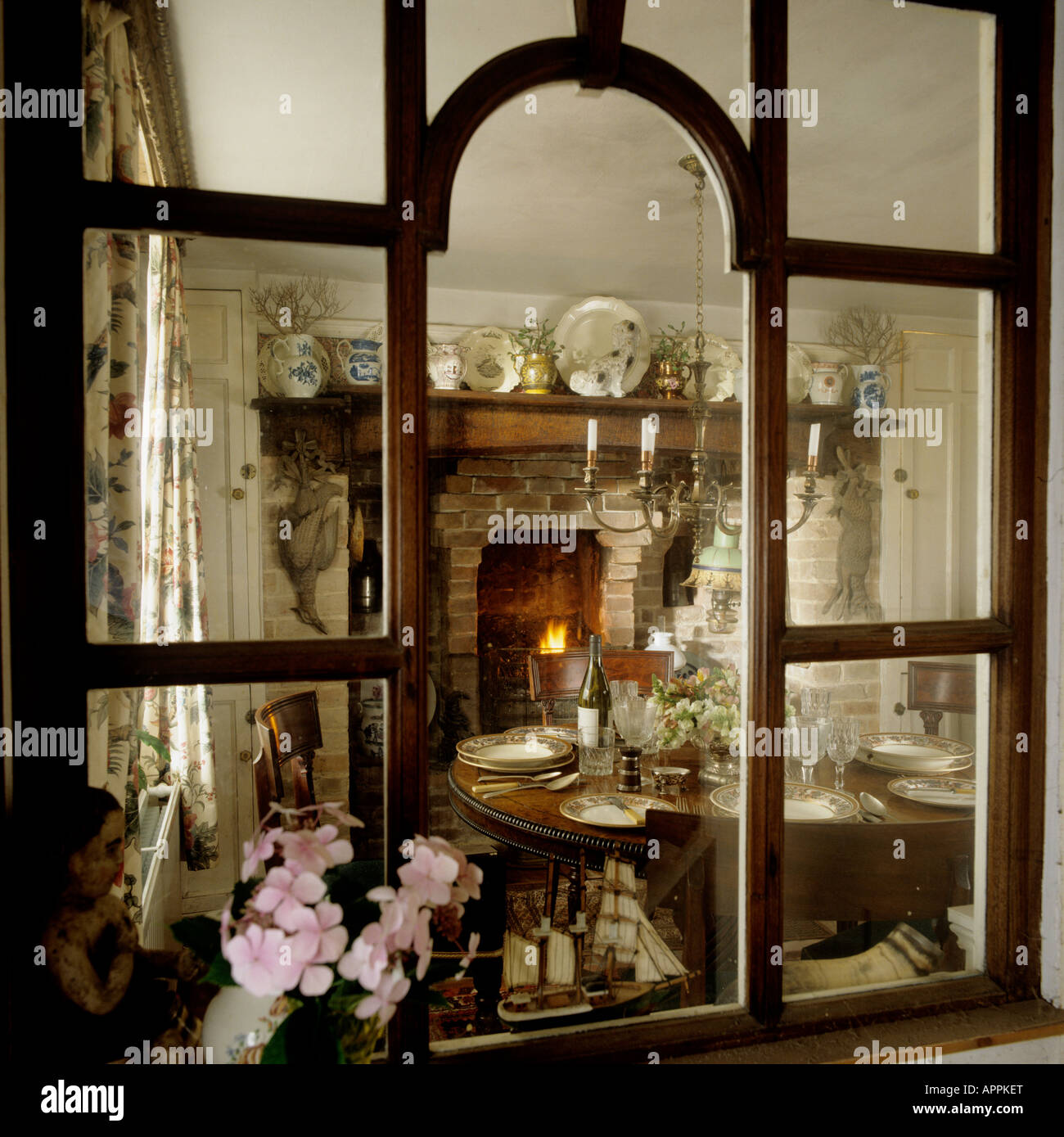 View through cottage window into dining room with open fireplace Stock ...