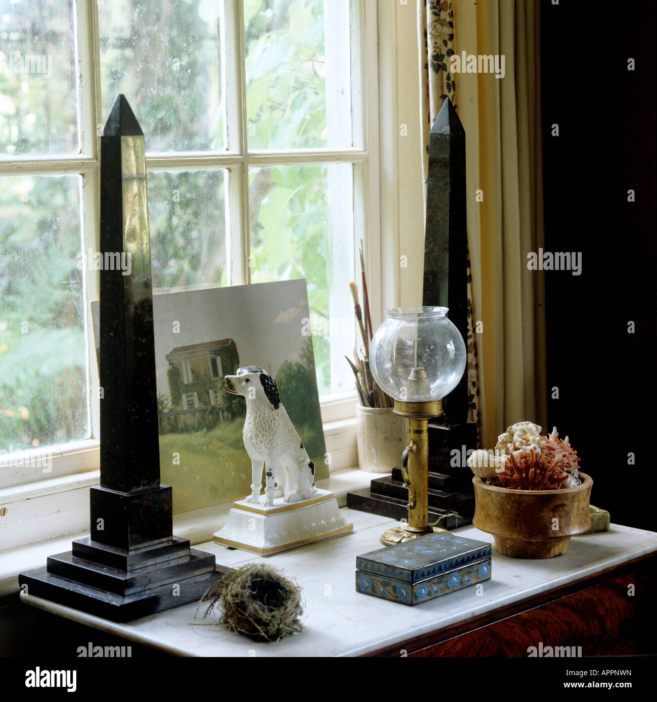 Obelisks and other ornaments on marble topped table in window Stock ...