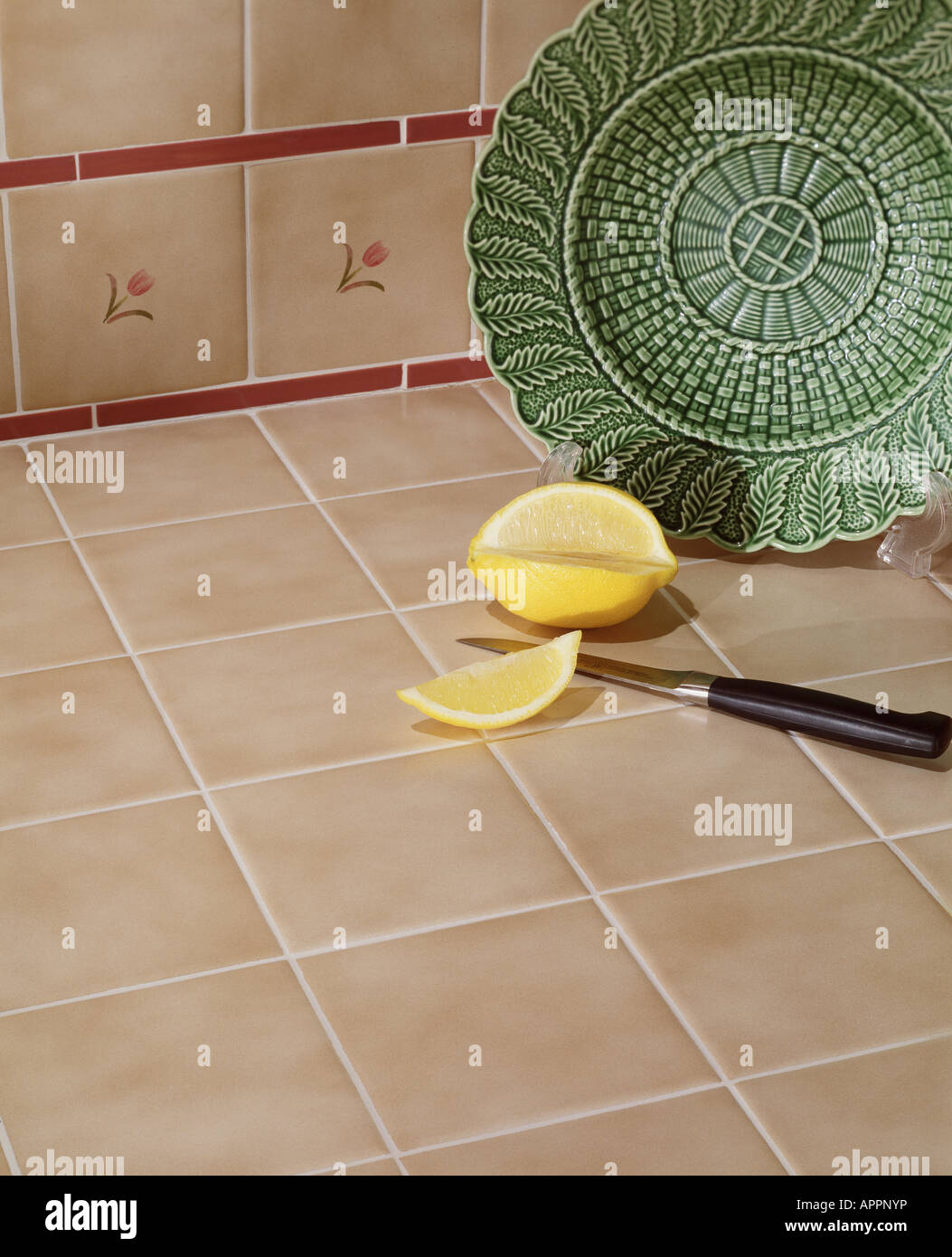 colorful dinner plate lemon slice paring knife on ceramic tile counter ...