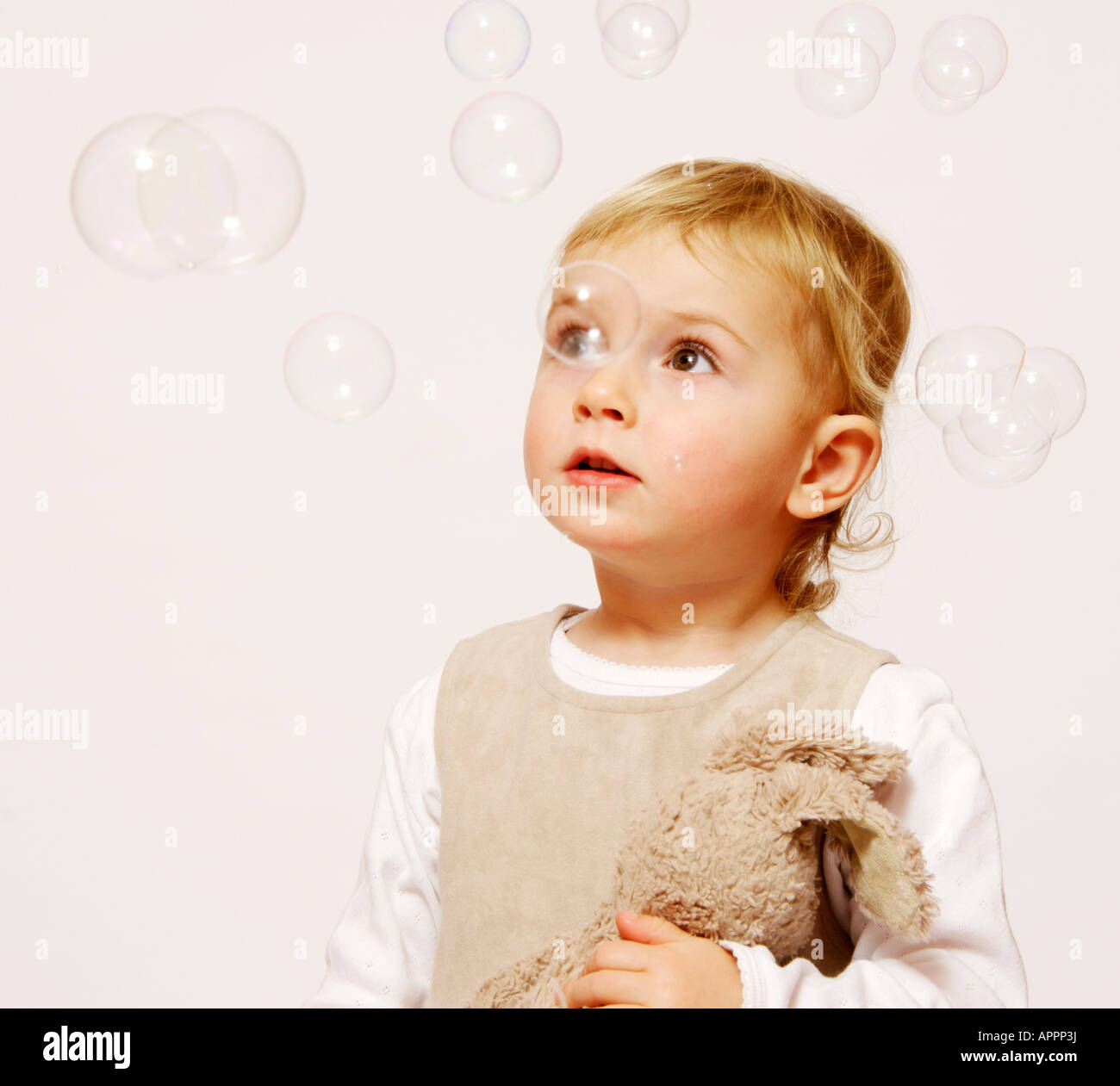 Young girl looking in wonder at bubbles Stock Photo - Alamy