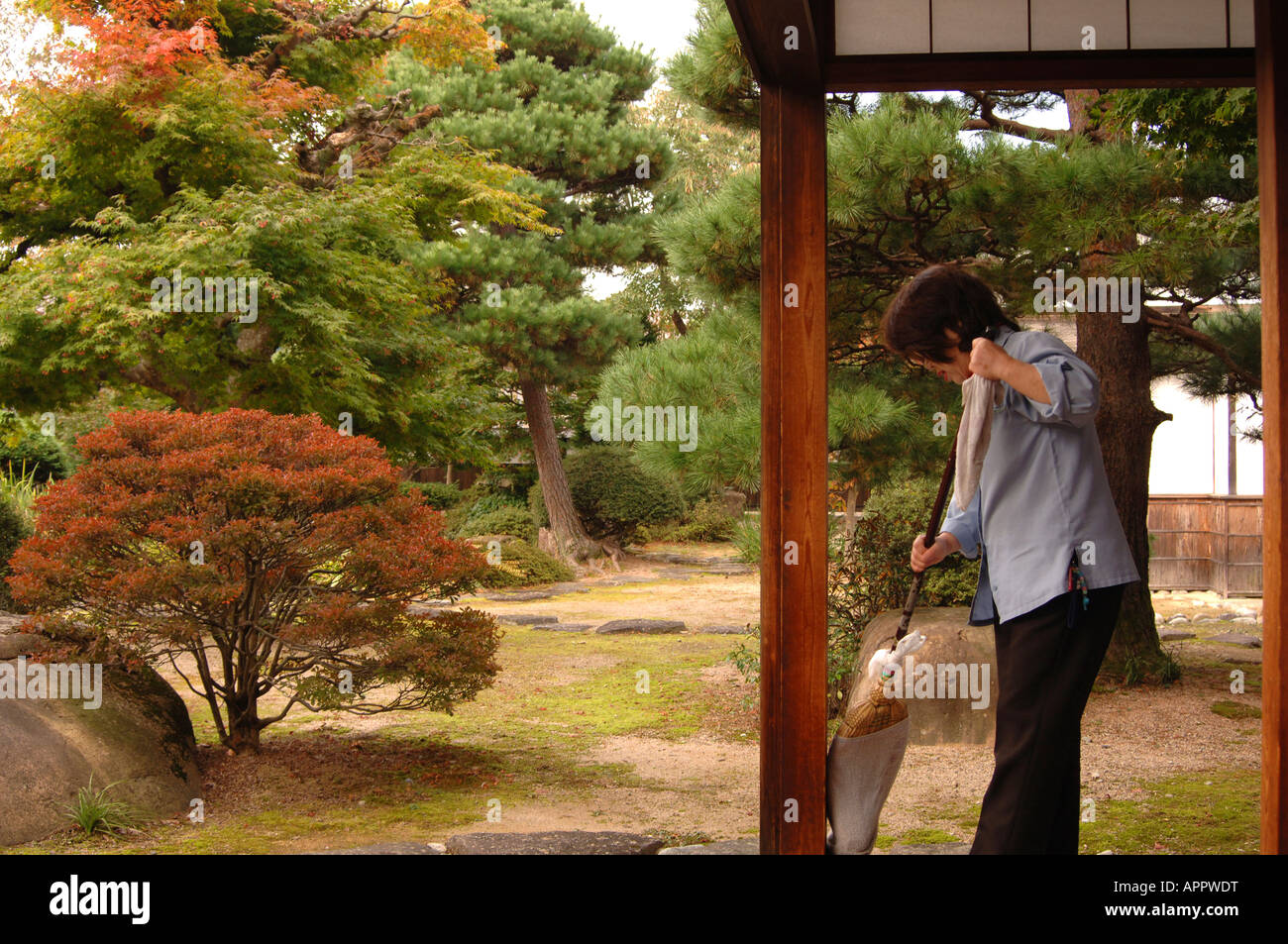 Maid sweeping porch of Japanese garden Stock Photo - Alamy