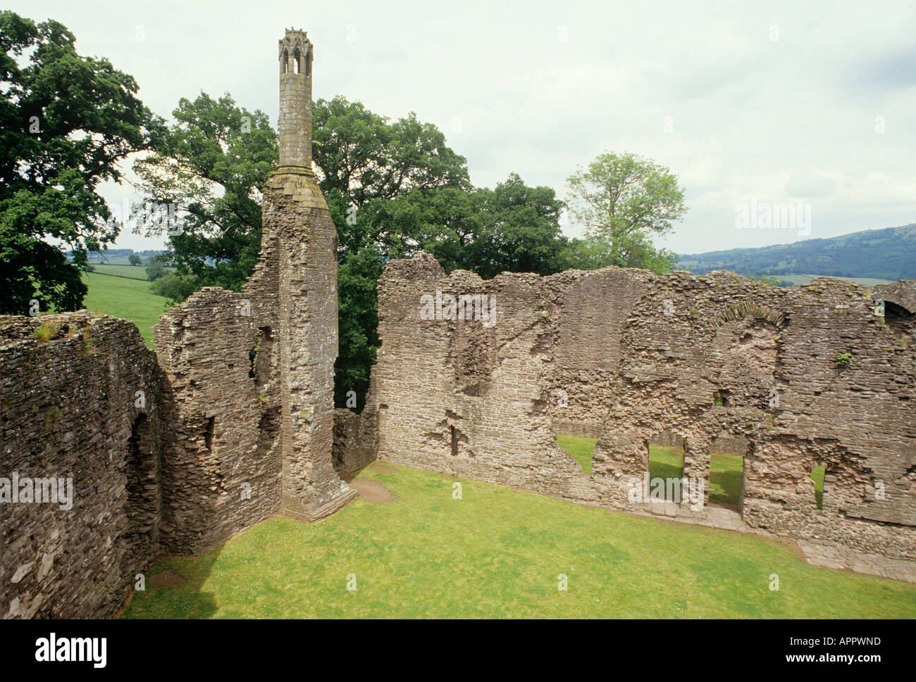 A grey stone pinnacle stands above the ruined frame of the 13th century ...