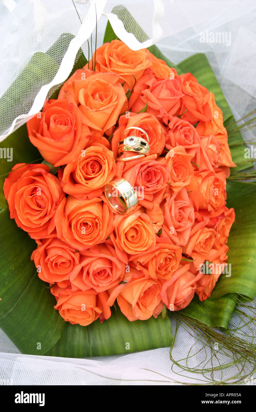 Wedding rings in orange bouquet of roses Stock Photo - Alamy