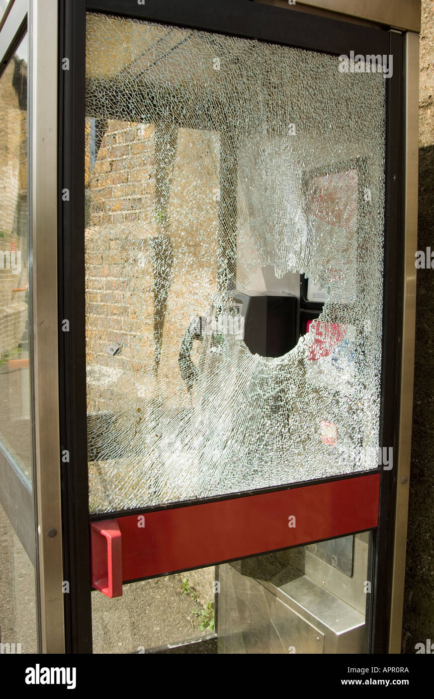 smashed up telephone box with broken glass Stock Photo - Alamy