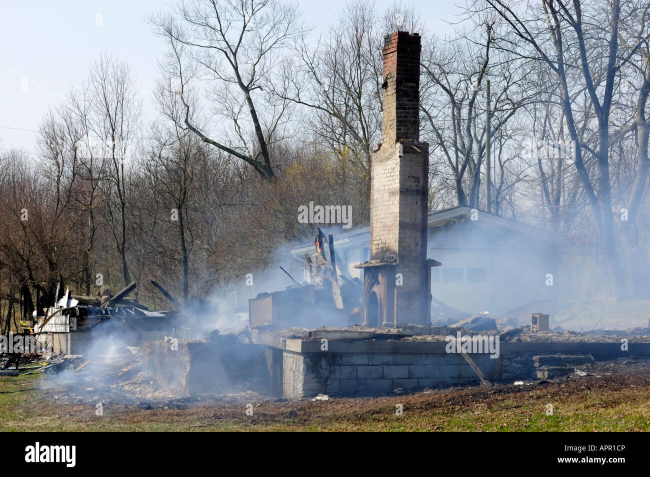Smoking ruins of a house with only the chimney standing after a fire ...