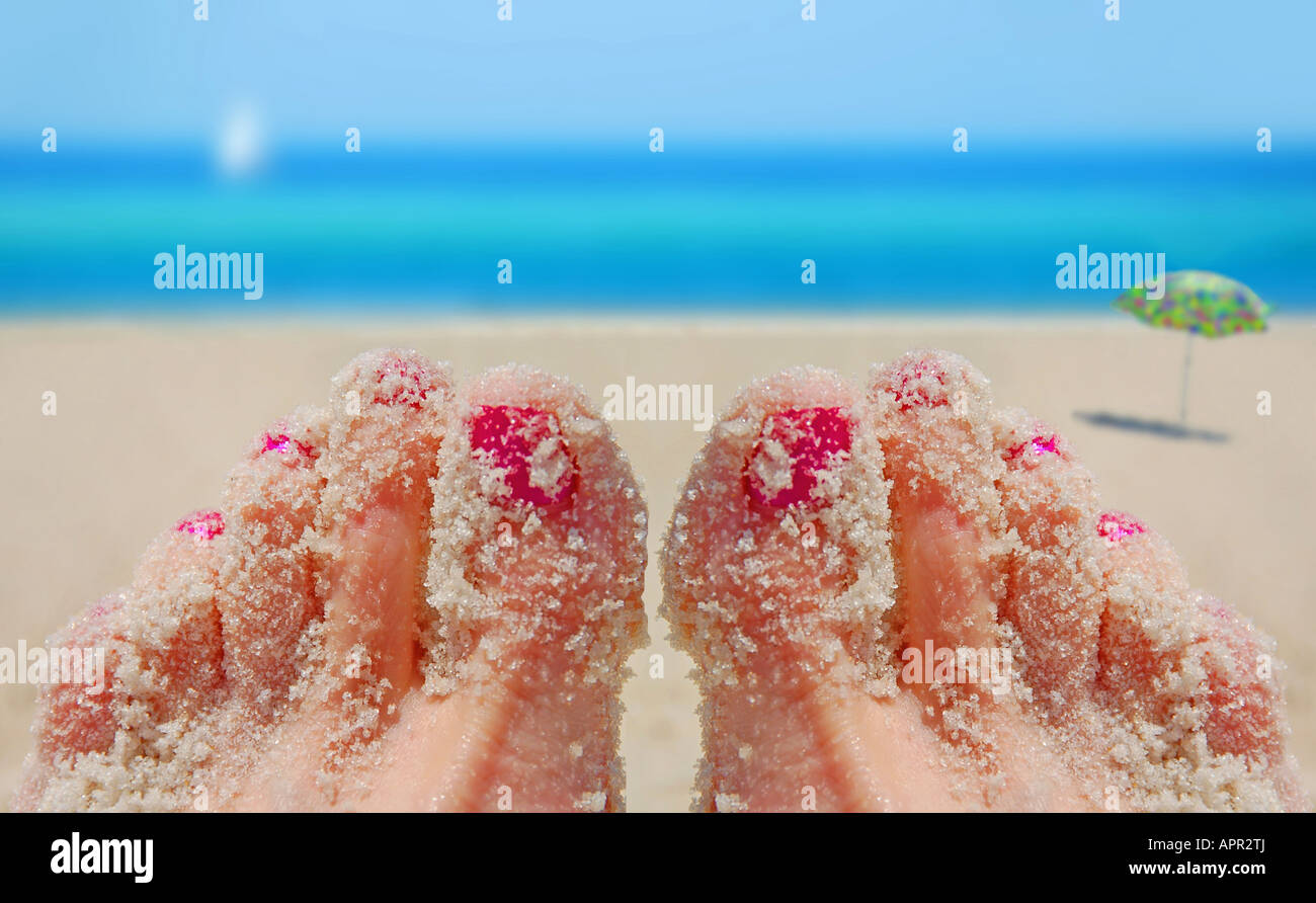 Sandy Toes on Beach with Umbrella and Sailboat in Distance Stock Photo ...