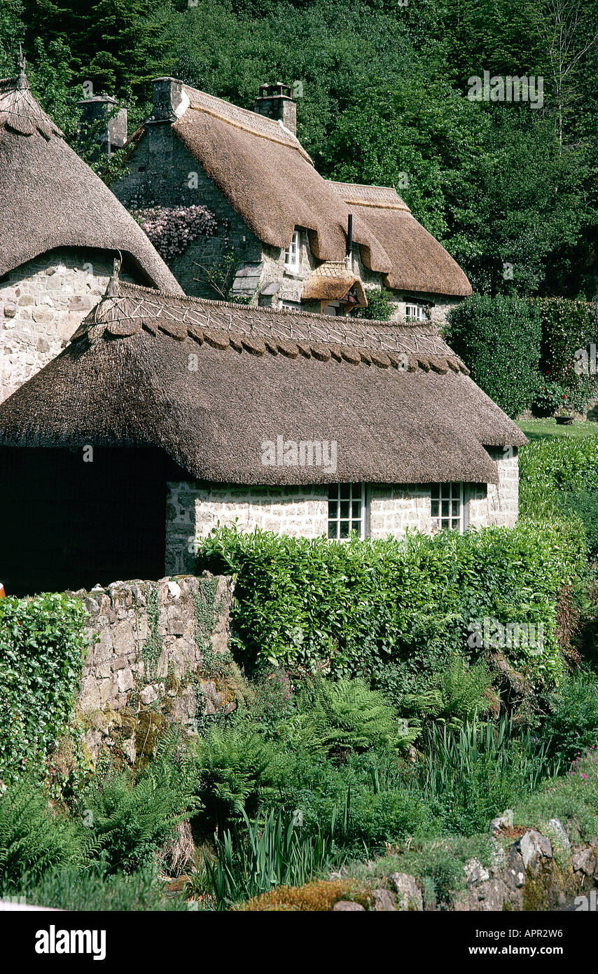 Thatched stone cottages on a slope with much greenery at Buckland in ...