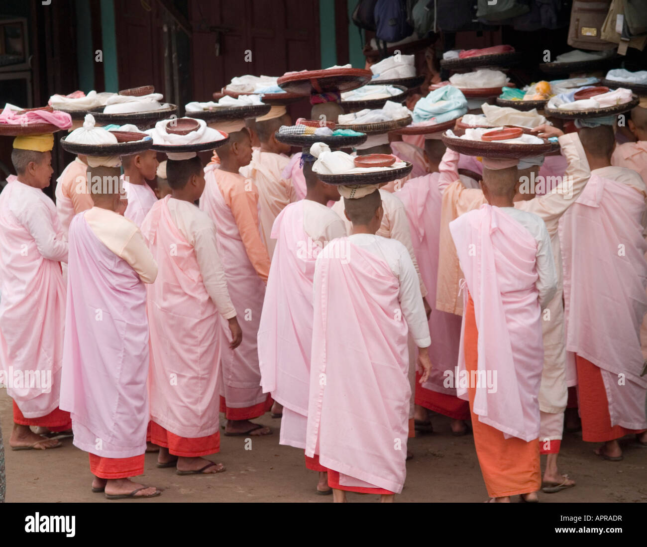 a lineup of nuns receiving alms in the old city of Bagan in Myanmar ...