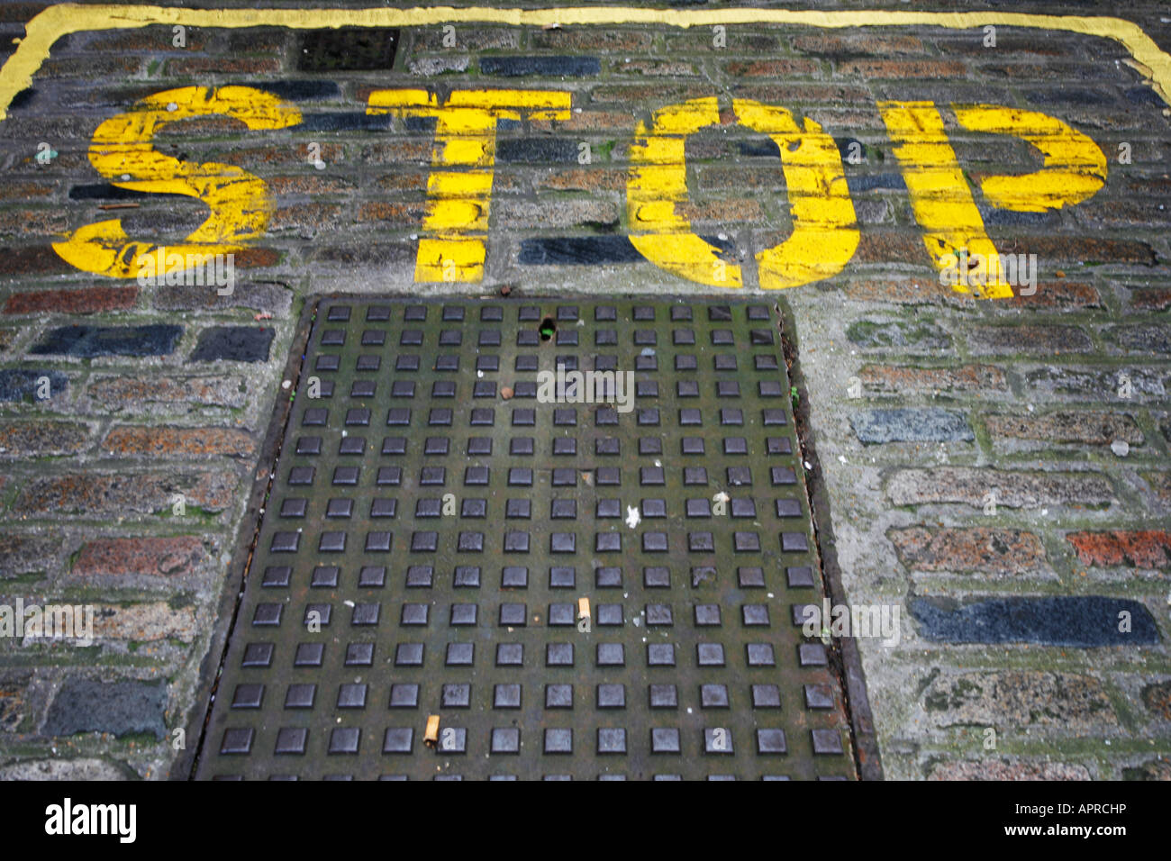 yellow stop sign on cobbled street, London Stock Photo - Alamy