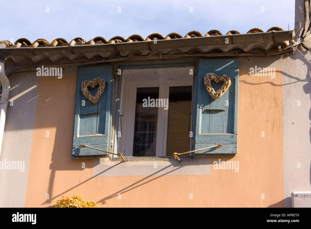 pink cottage with blue shuttered window Stock Photo - Alamy