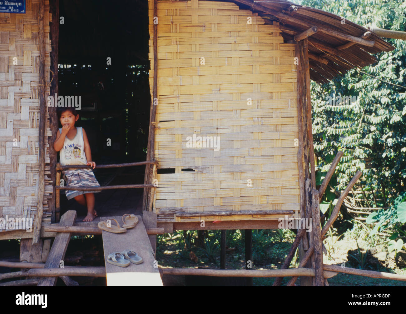 kid outside wooden house, Laos Stock Photo - Alamy