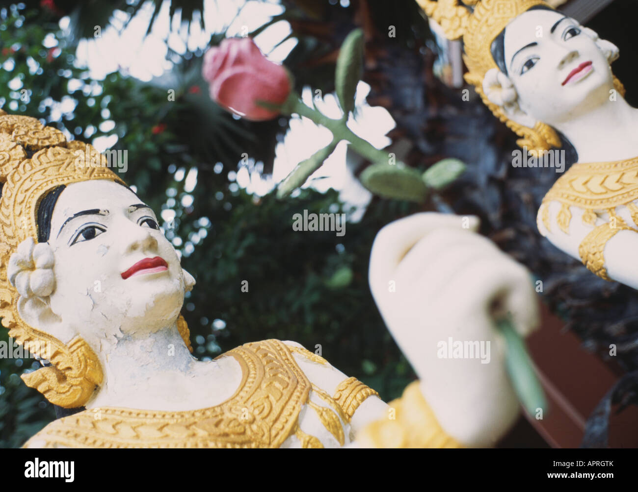 Gold thai statue holding pink rose hi-res stock photography and images ...