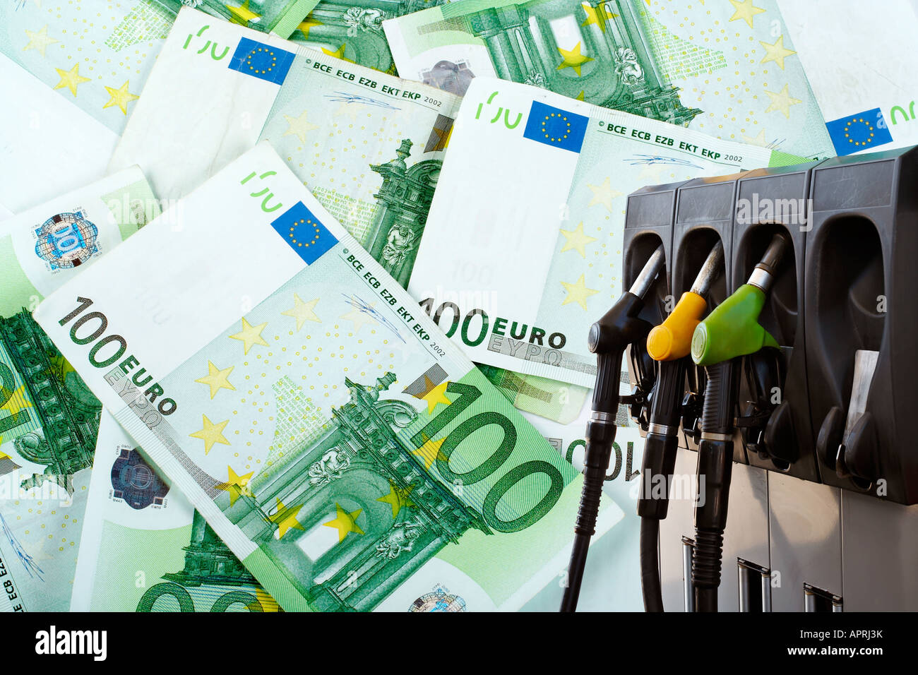 Three gas pump nozzles over a money background Stock Photo - Alamy
