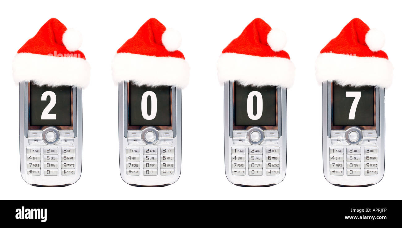 Four cellular mobile phones with a red christmas hat on a white ...