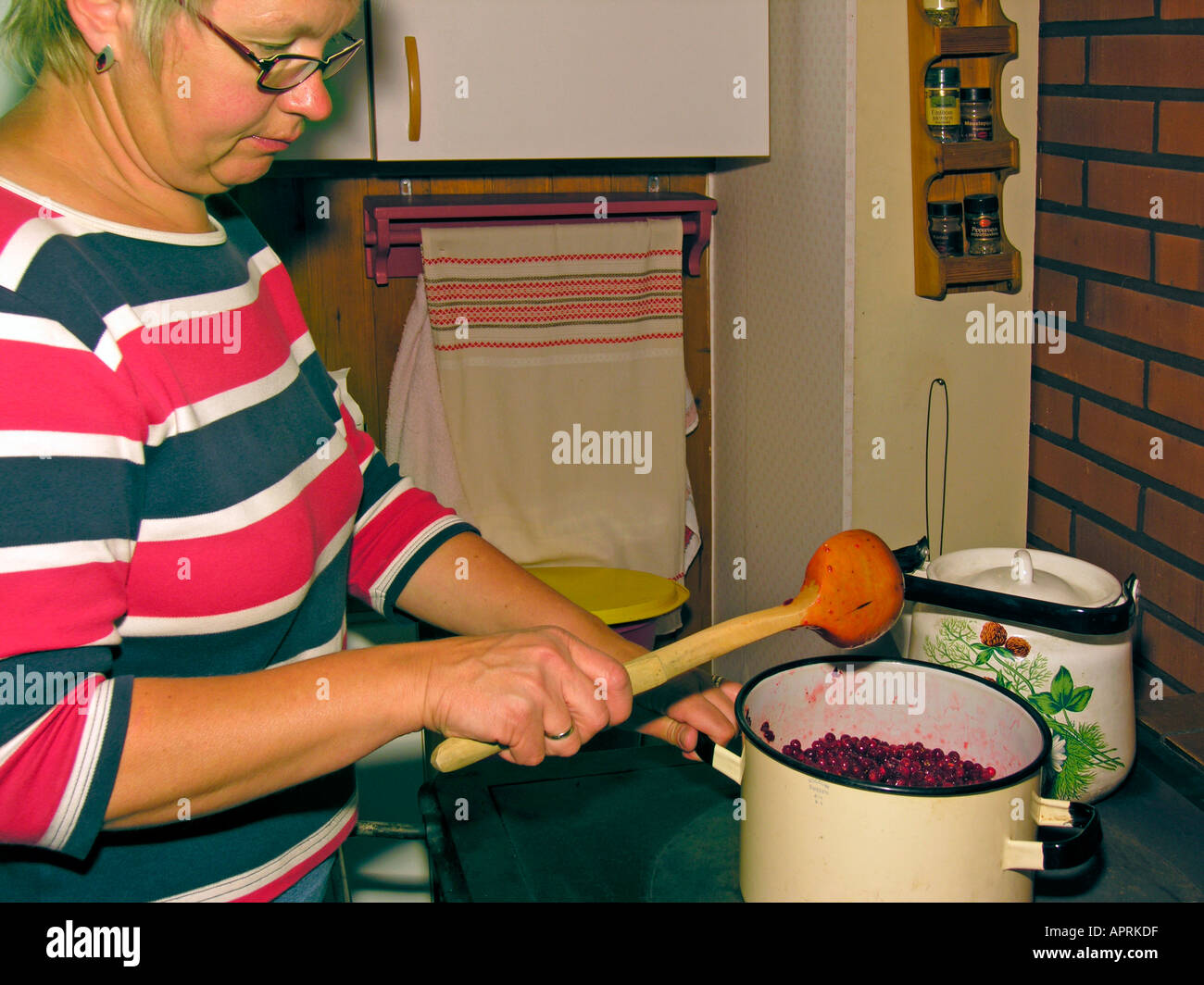 MR PR woman making jam on an old wood fired oven in an old kitchen ...