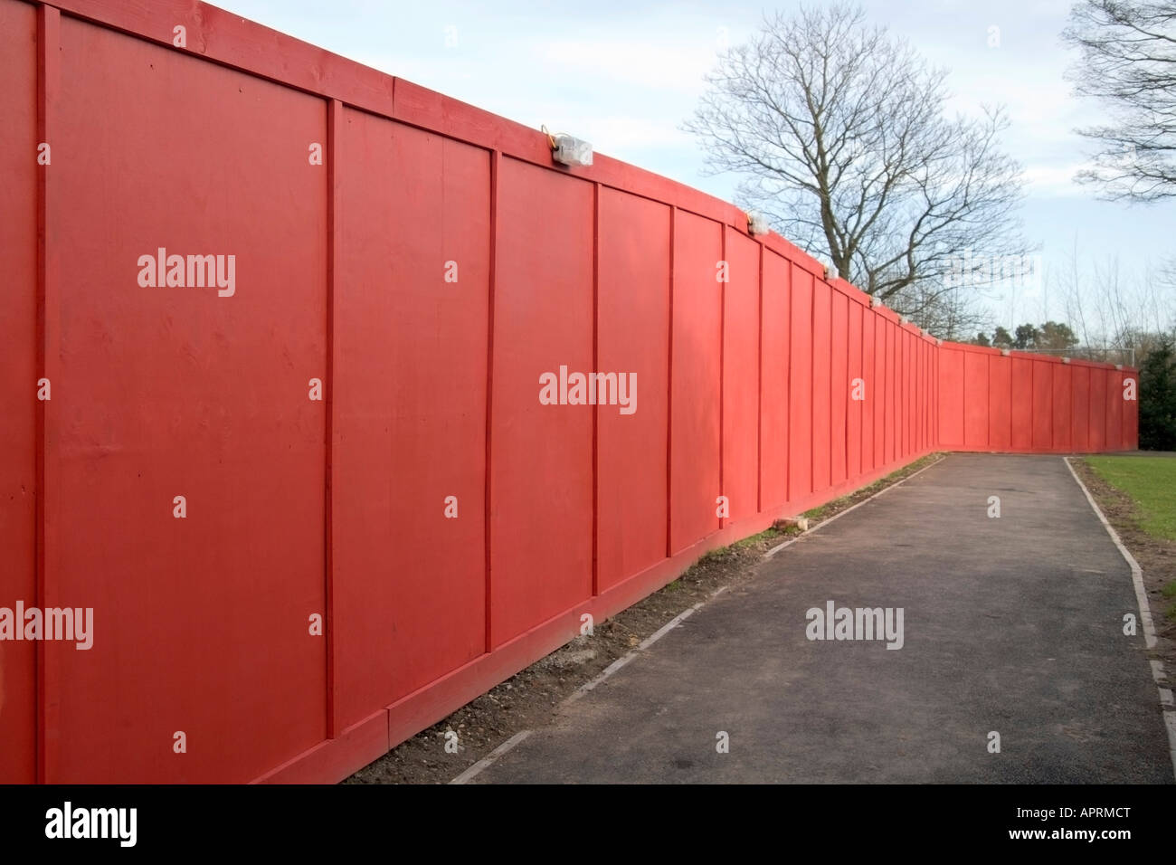 A red fence with a footpath alongside Stock Photo - Alamy