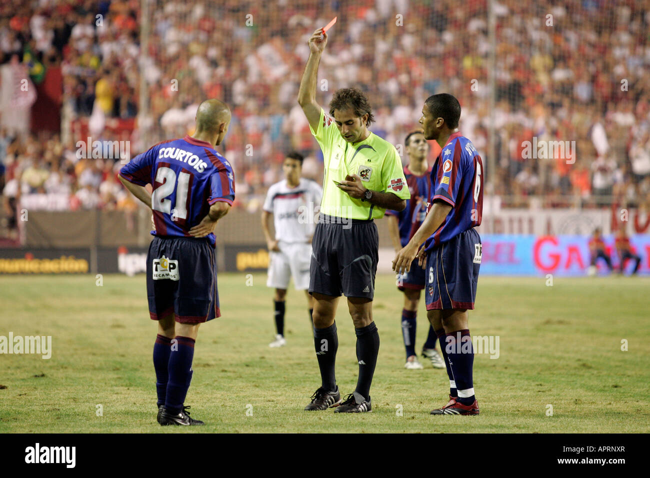 The referee booking Courtois with the red card Stock Photo - Alamy