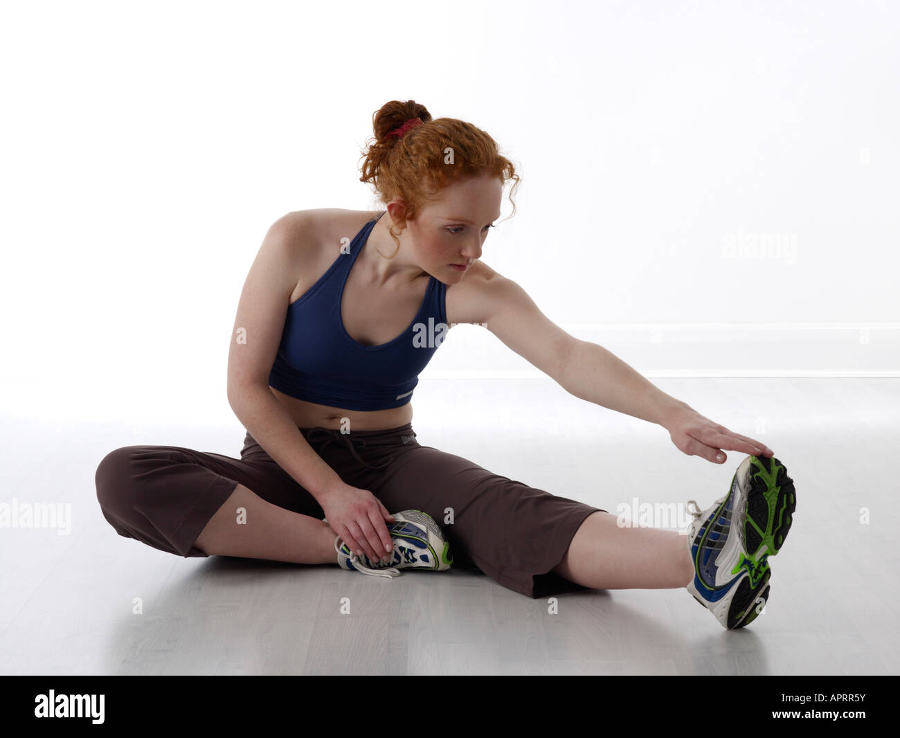Young woman doing stretching excercises in a gym Stock Photo - Alamy