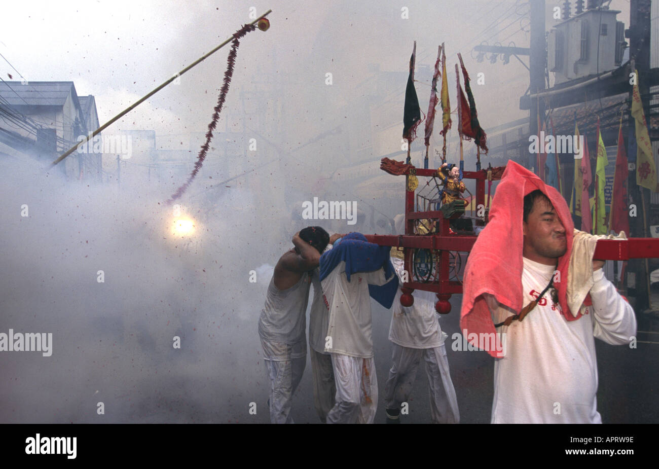 Fire crackers are thrown at a religious procession to scare away evil ...