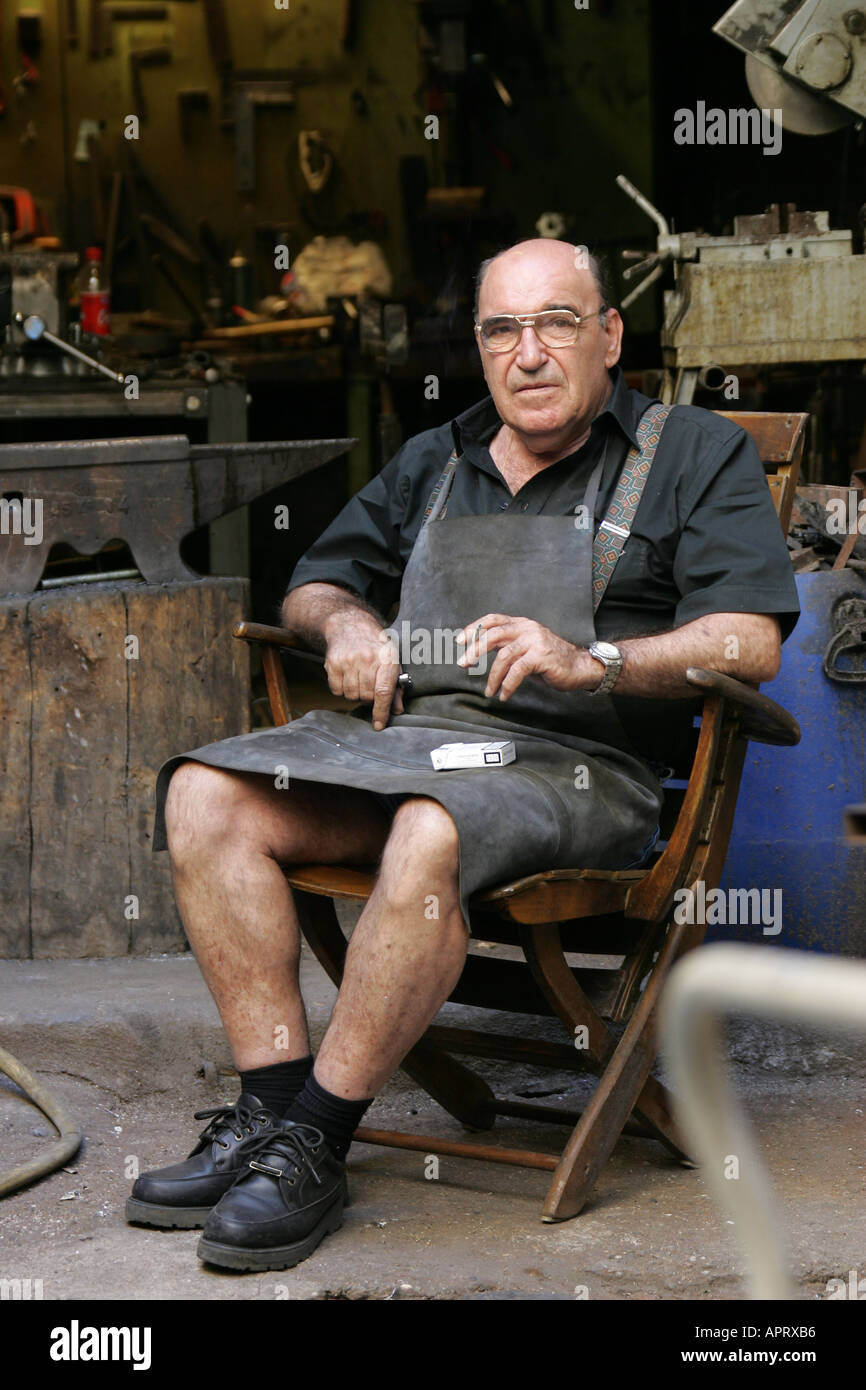 TRADITIONAL BLACKSMITH SAT OUTSIDE HIS WORKSHOP IN THE OLD TOWN OF ...