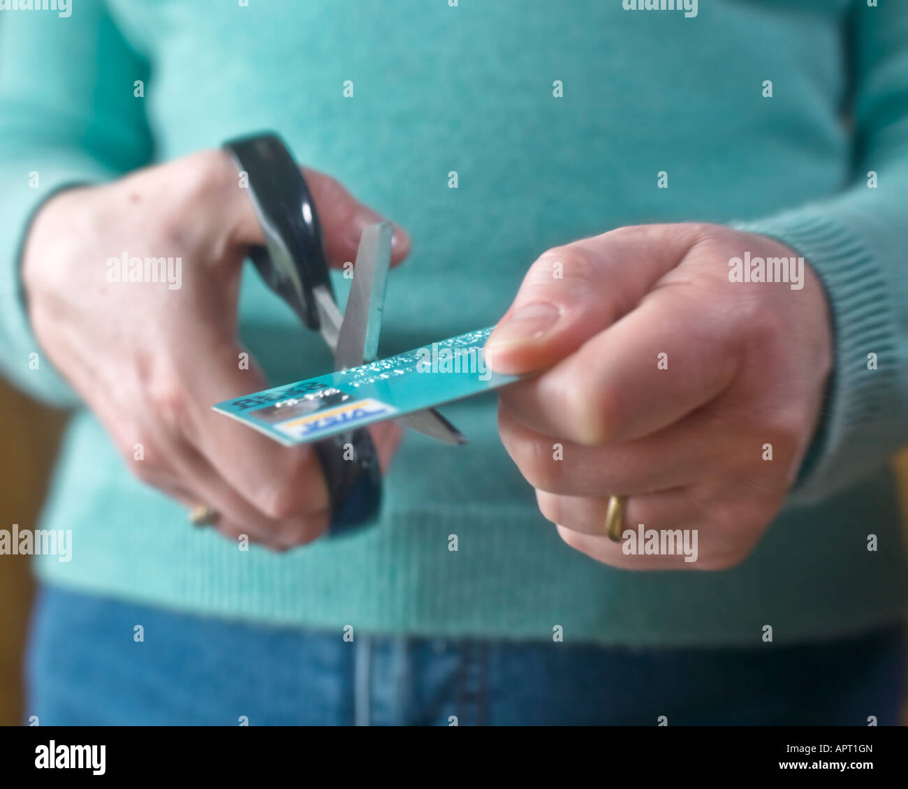 Close of female hands cutting up a credit card with a pair of scissors ...