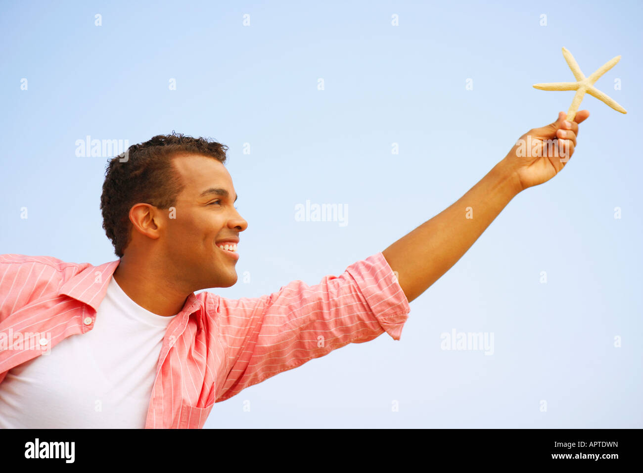 Hispanic man holding starfish Stock Photo - Alamy