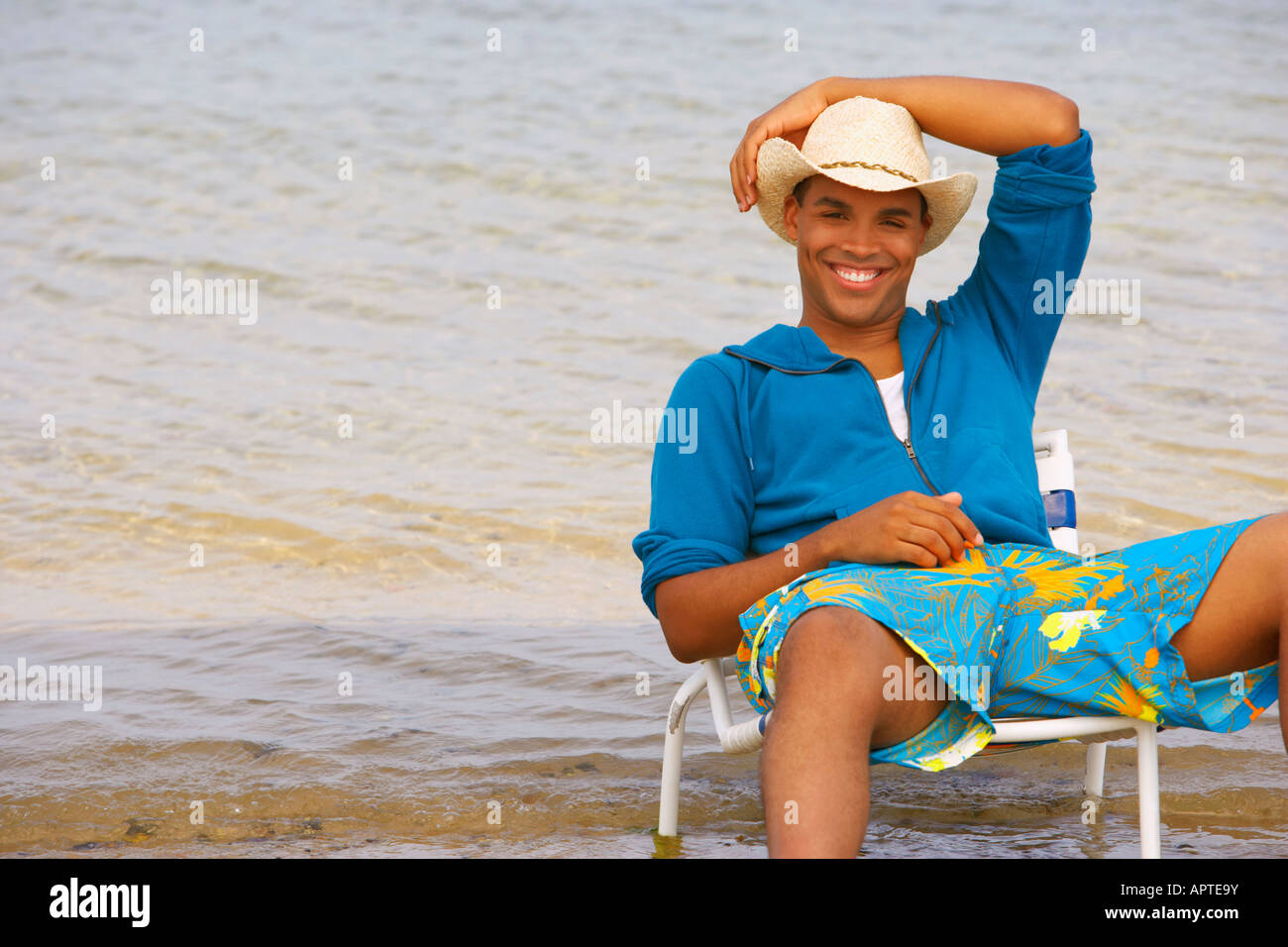 Hispanic man sitting in beach chair Stock Photo - Alamy