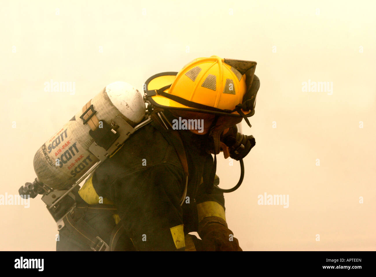 A firefighter in a yellow LT helmet at an emergency fire scene ...