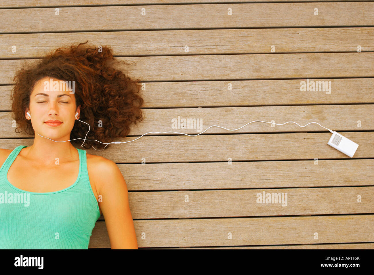 Young woman listening to mp3 player Stock Photo - Alamy