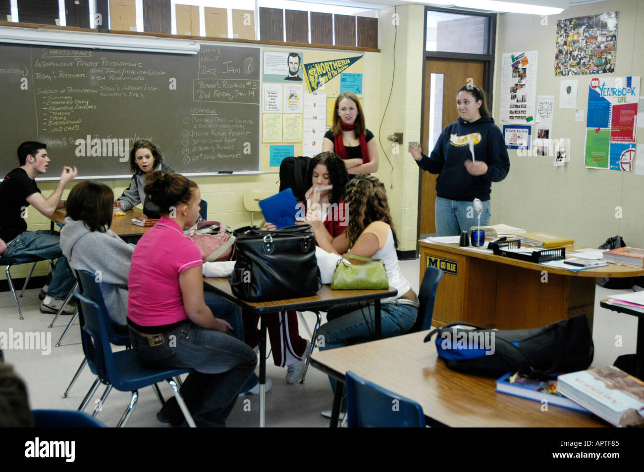 Female high school student leads class project by speaking to a group ...